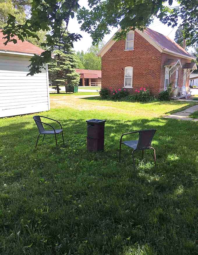 Two simple chairs create an intimate conversation spot beneath towering trees &ndash; morning coffee has never had a more peaceful setting.