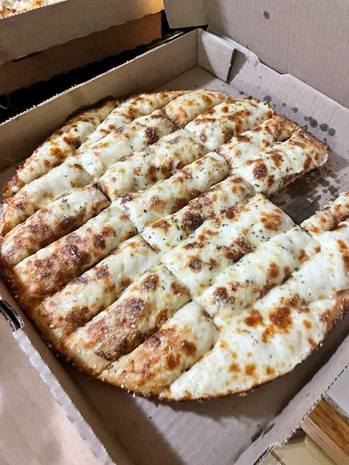 Breadsticks emerge from the kitchen like edible treasure, perfectly golden and begging to be dipped in something delicious.