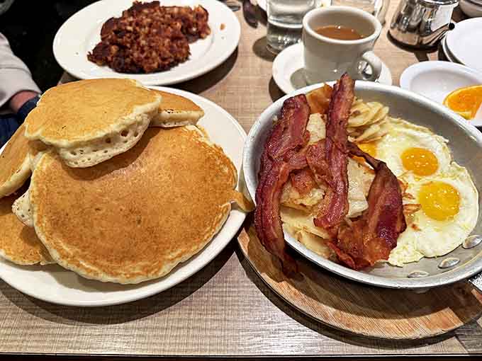 Eggs Benedict reimagined: poached eggs perch atop crispy hash browns, proving that Colossal Cafe's breakfast genius extends beyond their famous sandwiches.
