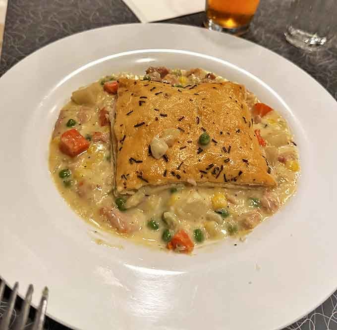 Grandpa Jean's Chicken Pot Pie arrives with a golden crust that practically begs to be broken into. Steam escapes like delicious memories.