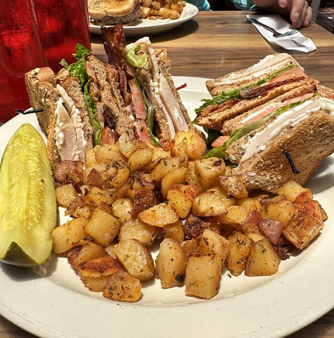 Club Sandwich: Architecture meets appetite in this towering testament to sandwich engineering &ndash; layers of goodness flanked by those legendary home fries.