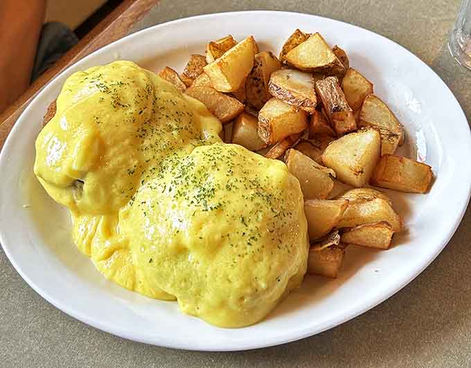 Eggs Benedict elevated to an art form &ndash; perfectly poached eggs nestled on crispy potatoes with hollandaise sauce cascading like a golden waterfall.