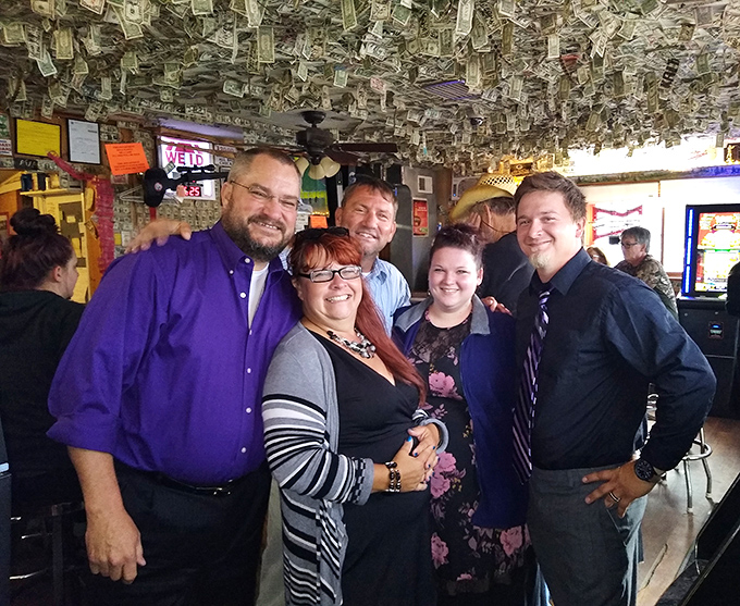 Happy patrons gather beneath the money ceiling, creating memories worth far more than the dollars overhead.