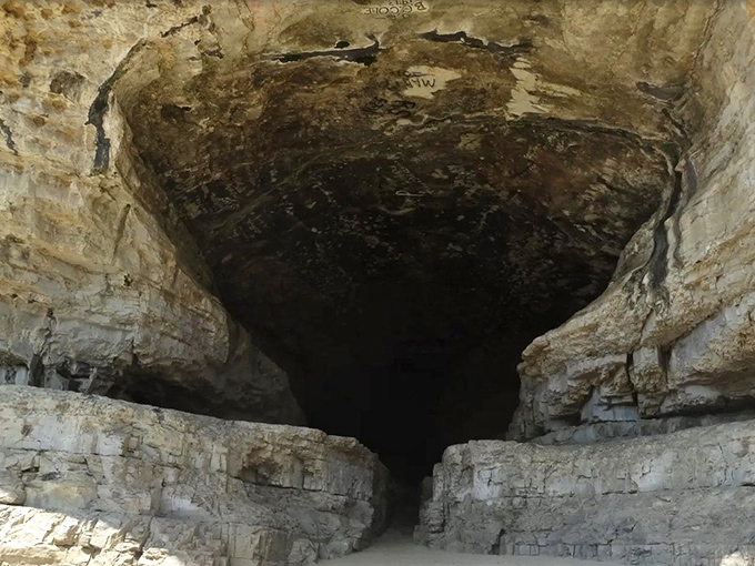 Peering into the darkness reveals a cavern that once sheltered river pirates, frontier families, and now curious hikers seeking natural wonders.