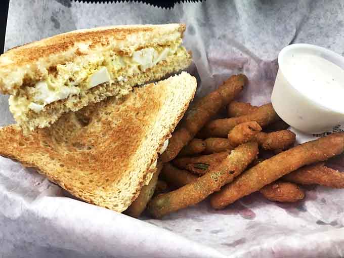 The humble egg salad sandwich elevated to art form, paired with crispy fried green beans that somehow make you feel virtuous despite the breading.