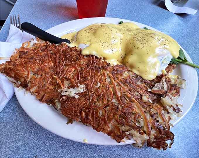 Eggs Benedict Florentine showcases The Uptowner's hollandaise mastery – velvety sauce cascading over spinach and perfectly poached eggs.