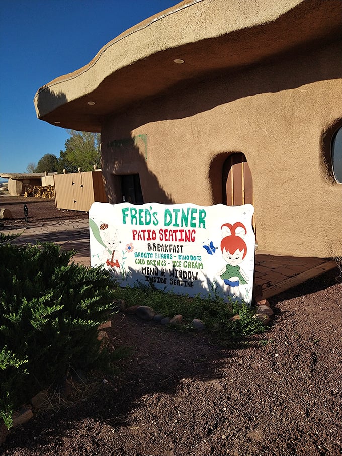 Fred's Diner promises Stone Age sustenance with its charming sign advertising breakfast, burgers, and ice cream for hungry time travelers.