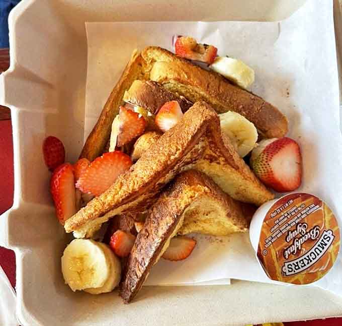 Golden-brown slices nestled among fresh strawberries and bananas create a breakfast worth lingering over, each bite a perfect balance of sweetness.
