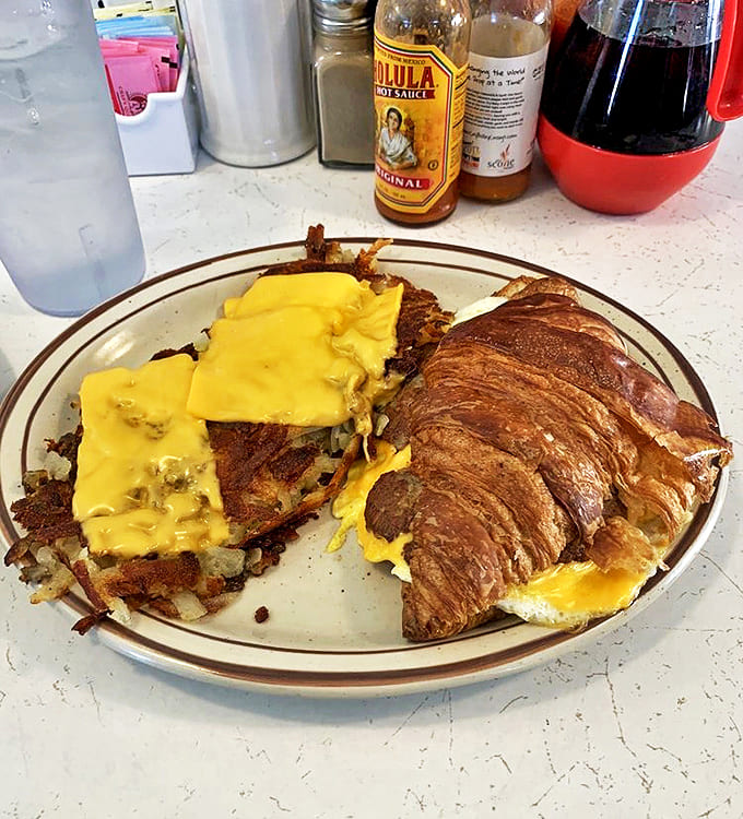 A study in contrasts: buttery croissant meets crispy hash browns, creating the breakfast equivalent of a beautiful friendship.