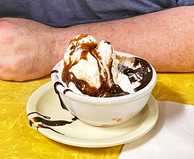 That hot fudge doesn't just drip – it clings lovingly to each spoonful, refusing to be left behind like a chocolate soulmate.