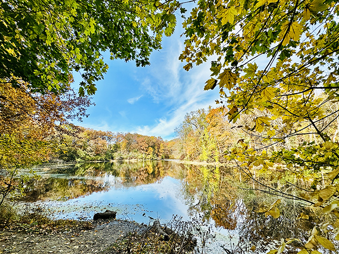 Mirror-like waters reflect autumn's finest wardrobe, doubling the visual feast for lucky visitors to this tranquil pond.