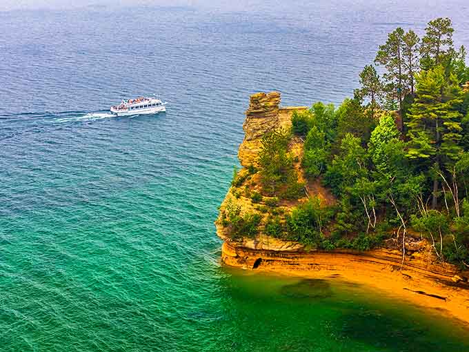That moment when you realize the postcard-perfect view is actually real &ndash; a tour boat providing scale to nature's magnificent canvas.