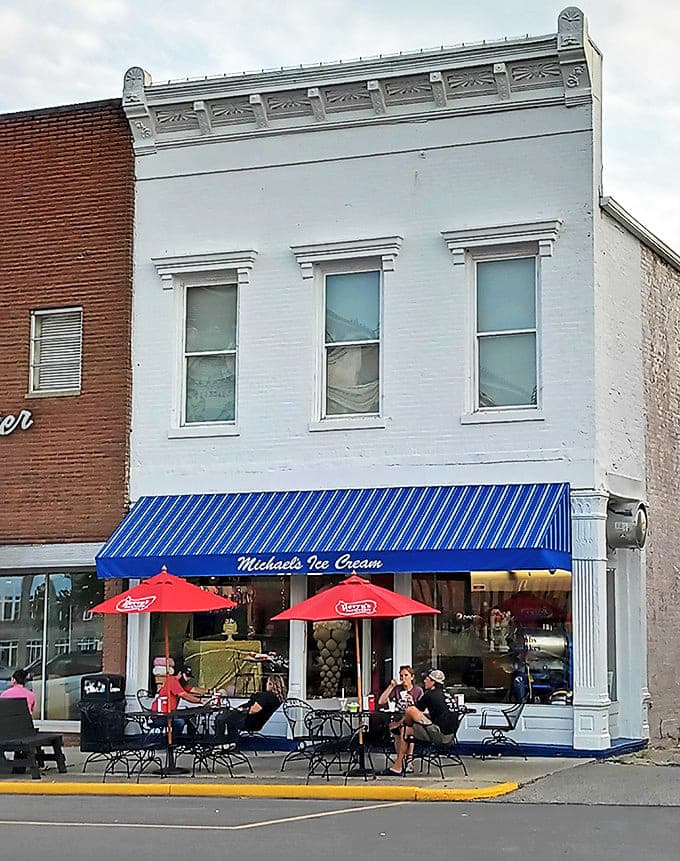 Summer perfection is found at Michael's outdoor seating area, where red umbrellas shade bubble-enjoying patrons watching small-town life unfold.