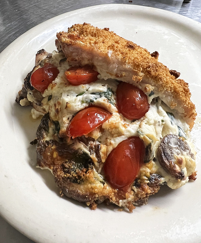 This stuffed chicken breast with roasted tomatoes proves Gil's culinary prowess extends well beyond their famous fried offerings.