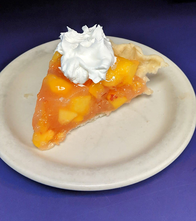 Peach pie so fresh and vibrant it practically sings summer anthems, topped with whipped cream that melts into sweet peachy rivers.