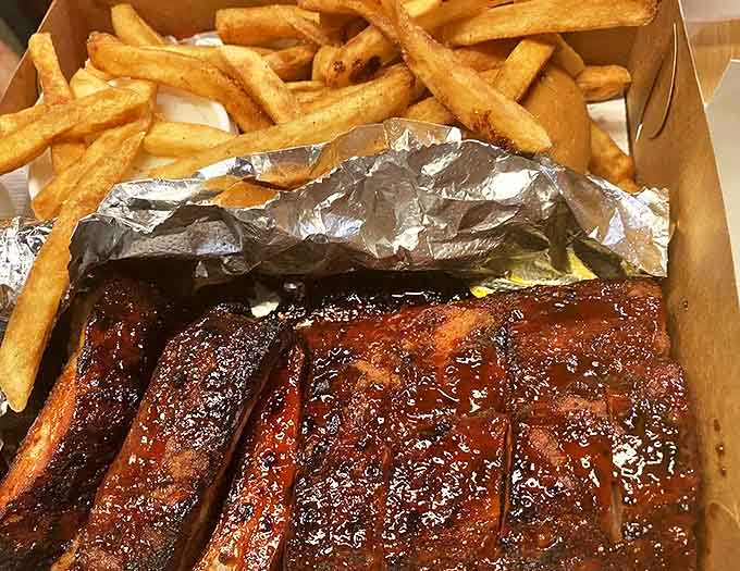 Golden fries playing the perfect supporting role to the star of the show, those glistening, sauce-lacquered ribs that demand your full attention.