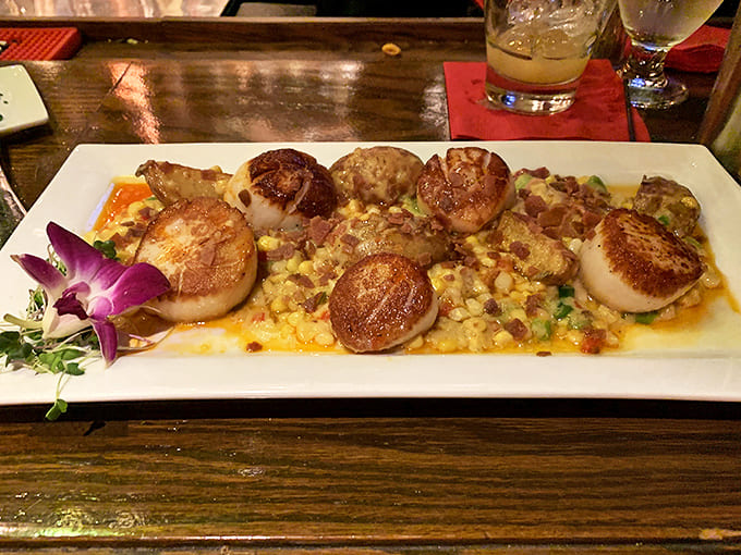 These scallops aren't just seared &ndash; they're transformed into buttery medallions of ocean flavor, nestled on a bed of colorful companions.