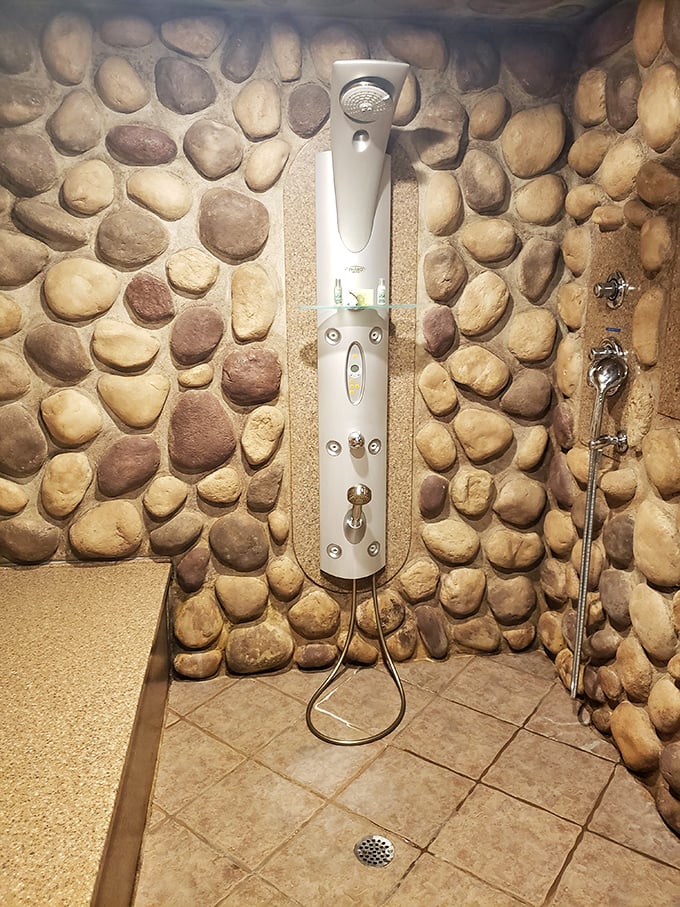 This stone-surrounded shower transforms a routine morning ritual into a refreshing waterfall experience in your private grotto.