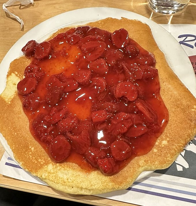 Berry bonanza! This strawberry-topped pancake doesn't just satisfy hunger &ndash; it crushes it beneath an avalanche of sweet, syrupy fruit. 