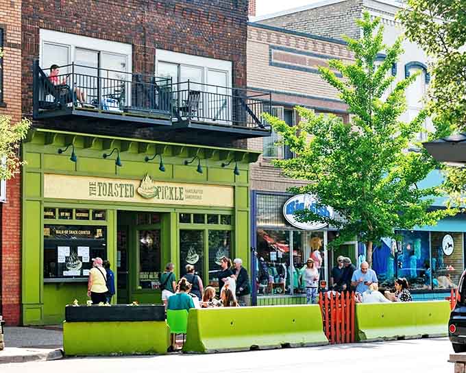 The Toasted Pickle's bright green facade stands out on the street, making it impossible to miss and hard to forget.