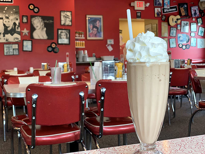 A vanilla milkshake stands tall against the backdrop of vintage decor &ndash; simple perfection in a classic soda fountain glass.