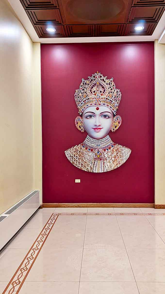 This ornate wall display features intricate detailing and vibrant colors, offering visitors a glimpse into the rich artistic traditions of Hindu culture.