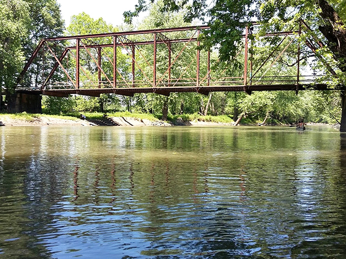 Reflections dance on the water's surface, mirroring the bridge's distinctive silhouette against an autumn sky.