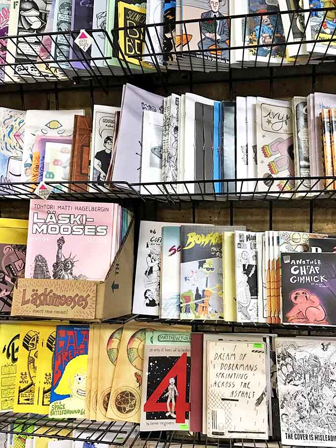 Handmade zines fill metal racks, each a tiny universe of creativity bound with staples and passion rather than marketing strategies.
