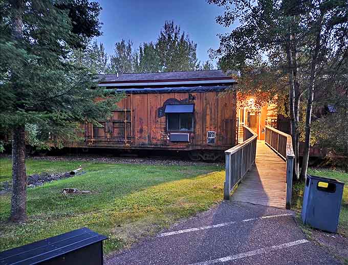 Twilight magic transforms these stationary boxcars into glowing beacons of comfort as day surrenders to evening.