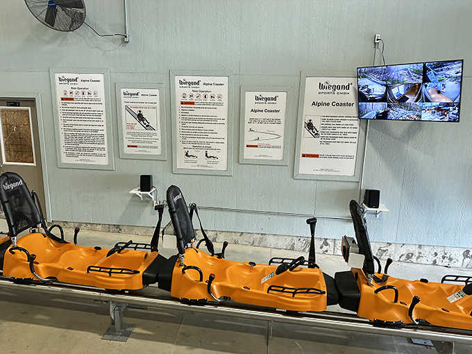 The chariots of thrill await their next passengers. These bright orange carts are engineered for both safety and maximum "wheeeee" factor.