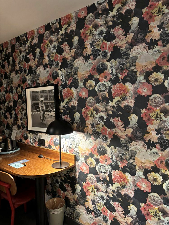 Bold floral patterns create a dramatic backdrop for the wooden desk where you might actually want to write postcards.