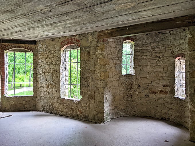 Multiple arched windows create a rhythm of light and shadow, playing across empty rooms once filled with life.