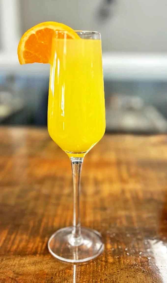 A mimosa that practically glows with freshness. That orange slice isn't just garnish &ndash; it's a promise of what's inside.