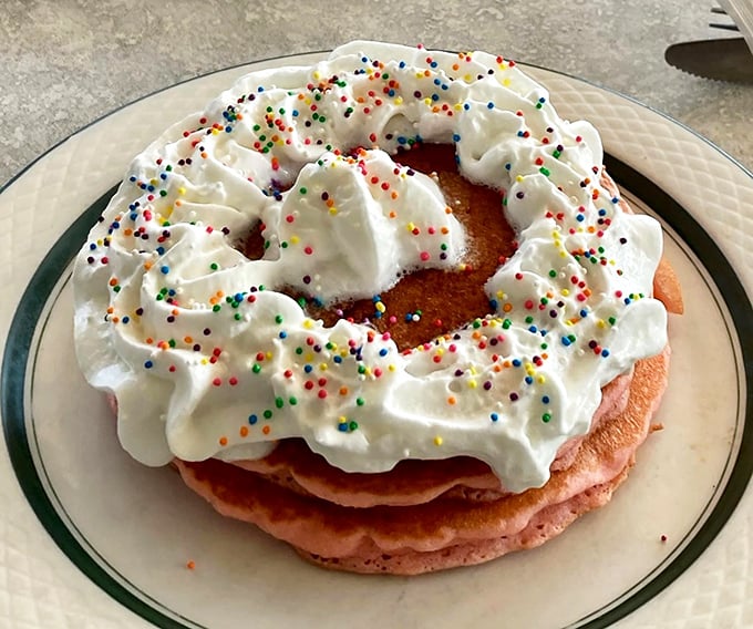 Whimsy meets breakfast &ndash; a towering creation topped with whipped cream and rainbow sprinkles proves that joy can indeed be served on a plate.