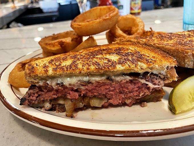 This isn't just a patty melt&mdash;it's a masterclass in sandwich architecture, where melted cheese meets juicy beef in perfect harmony. Those onion rings aren't just sidekicks; they're co-stars.