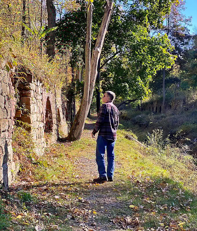 A visitor contemplates history: The scale of these industrial relics becomes apparent when standing beside their weathered stone walls.