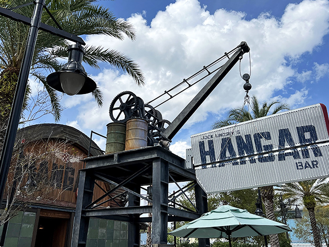 Jock Lindsey's Hangar Bar features an impressive industrial crane, nodding to its fictional aviation-themed backstory. The outdoor seating area welcomes Disney Springs visitors.