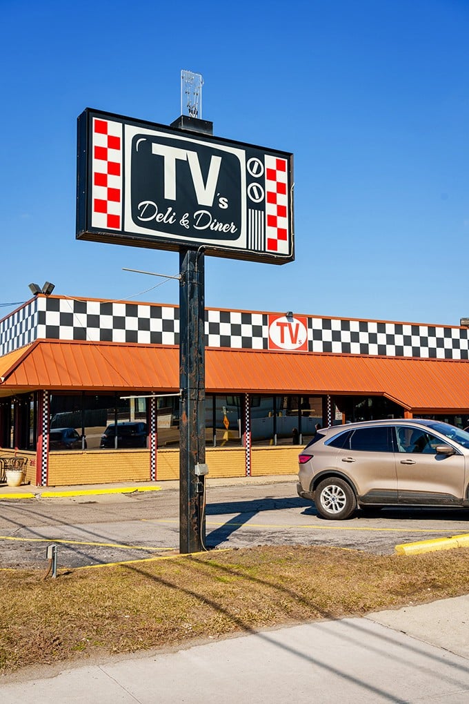 TV's Deli & Diner's bold checkered sign stands out against the blue sky, promising a menu that combines diner classics with deli favorites.