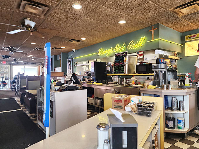 The neon "Kenny's Oak Grill" sign glows above the counter, casting that distinctive diner light that somehow makes everything taste better.