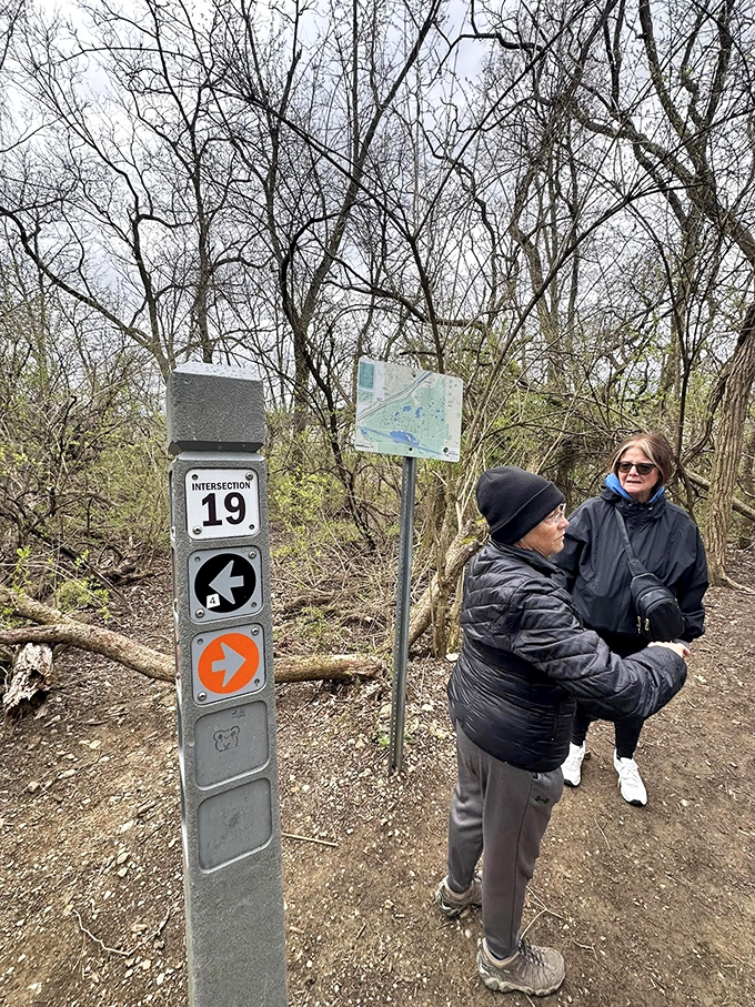 Friendly hikers stop to consult the map at Intersection 19, enjoying a beautiful spring day exploring the Palos Trail System.