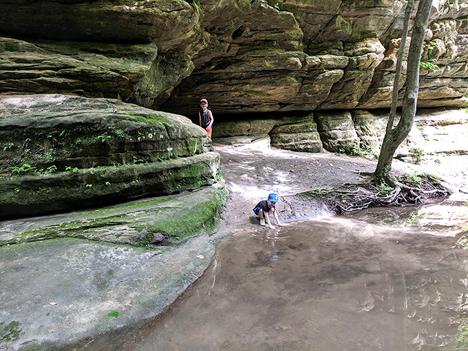 Young explorers discover the joy of puddle-splashing beneath towering canyon walls, where every splash echoes with childhood delight.