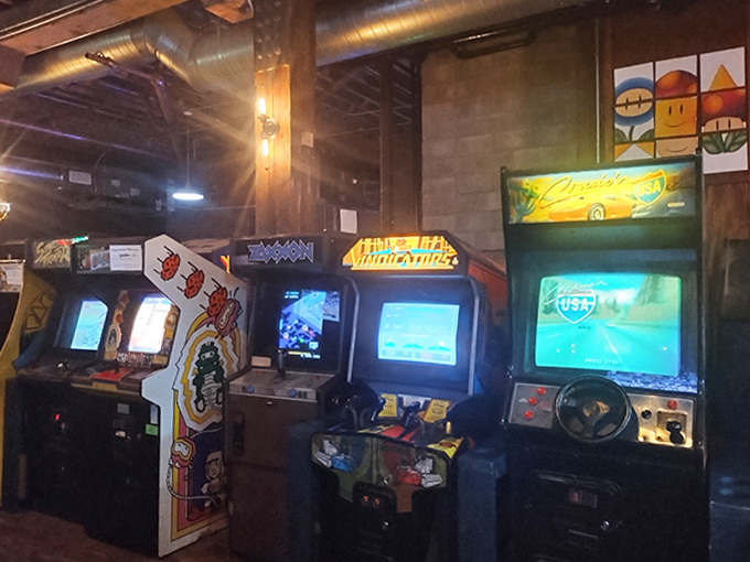 Classic arcade cabinets stand at attention like soldiers guarding the kingdom of your youth, each one a portal to simpler times.