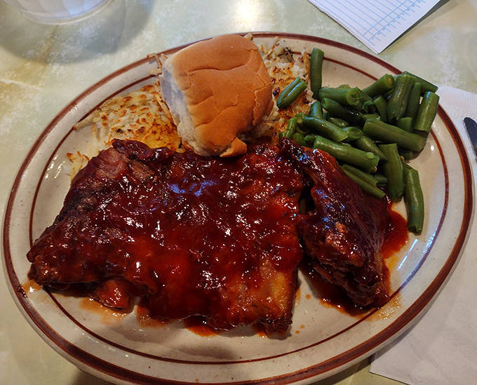 BBQ ribs that surrender from the bone at first touch, glazed with a sauce that balances sweet and tangy notes like a culinary tightrope walker.