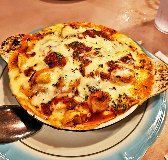 Baked tortellini bubbling with cheese that stretches from plate to mouth like it's auditioning for a food commercial.