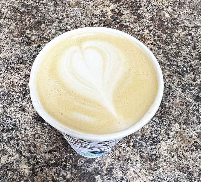 Coffee art meets liquid dessert in this velvety companion to your donut adventure &ndash; the heart swirl is just showing off.