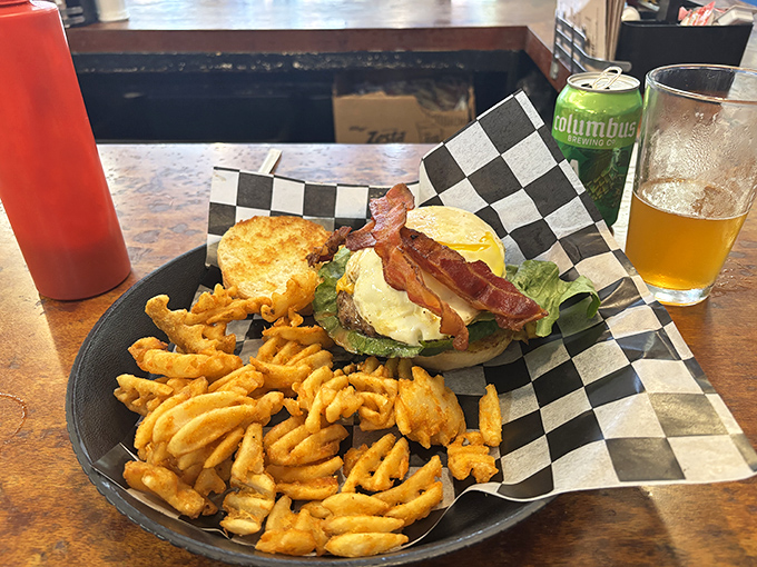 A burger that requires both hands and several napkins, paired with waffle fries that make regular fries question their life choices.