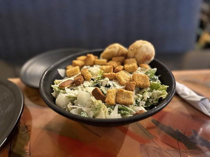 Even the Caesar salad gets the gallery treatment &ndash; crisp romaine, house-made croutons, and parmesan arranged like a fresh green landscape.