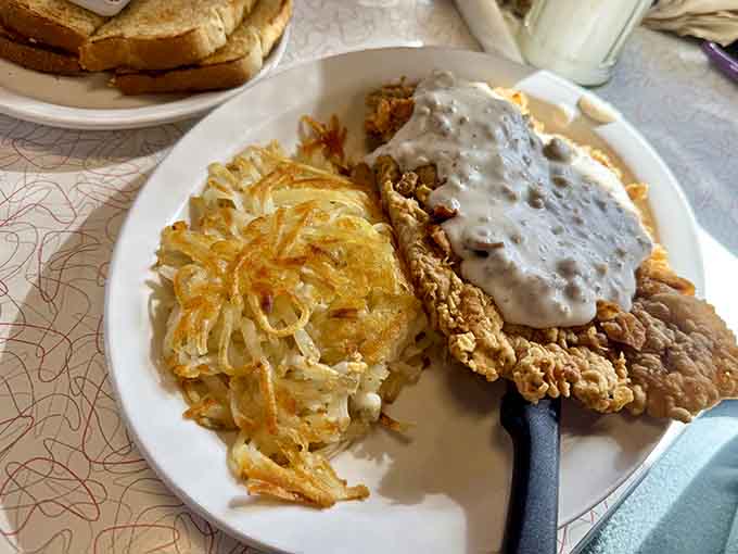 Country fried steak smothered in gravy alongside crispy hash browns, this is the breakfast that built America, folks.
