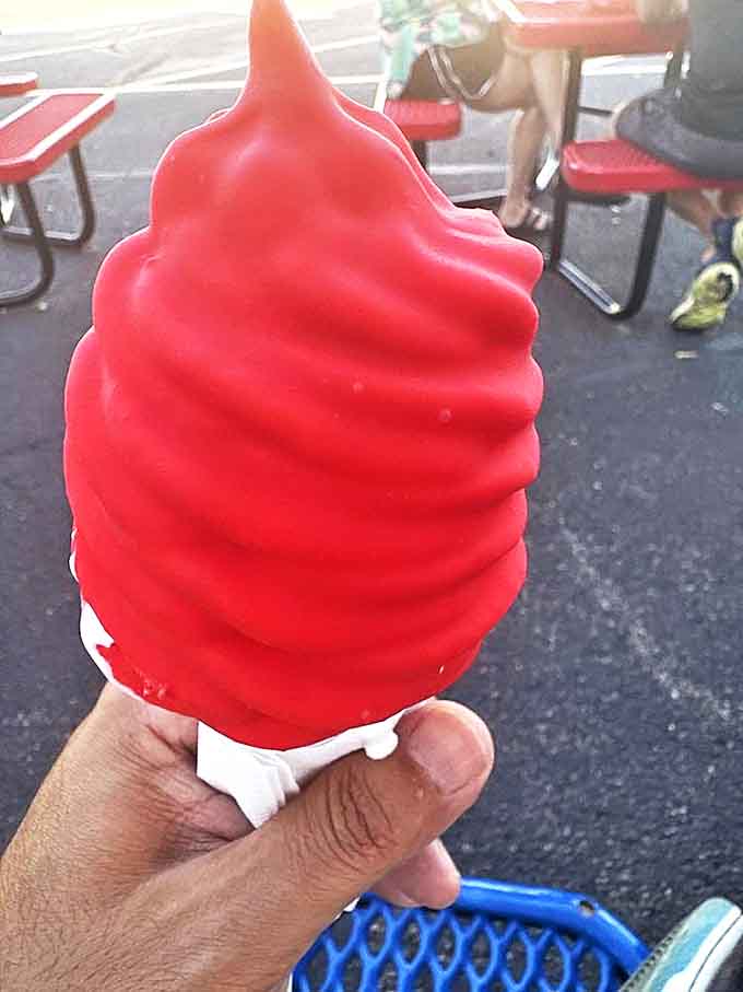 That cherry-dipped cone isn't just dessert, it's summer incarnate. The bright red coating shatters perfectly with each blissful bite.
