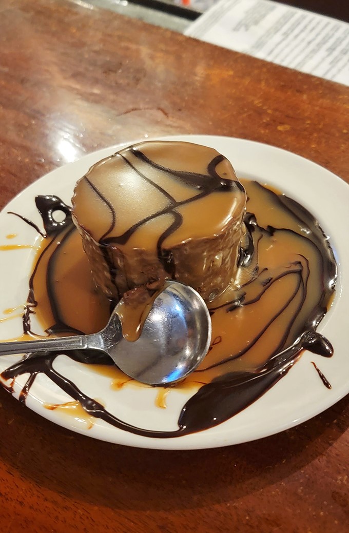 Chocolate mousse cake drizzled with artistic abandon &ndash; because after a seafood feast, your sweet tooth deserves its own standing ovation.